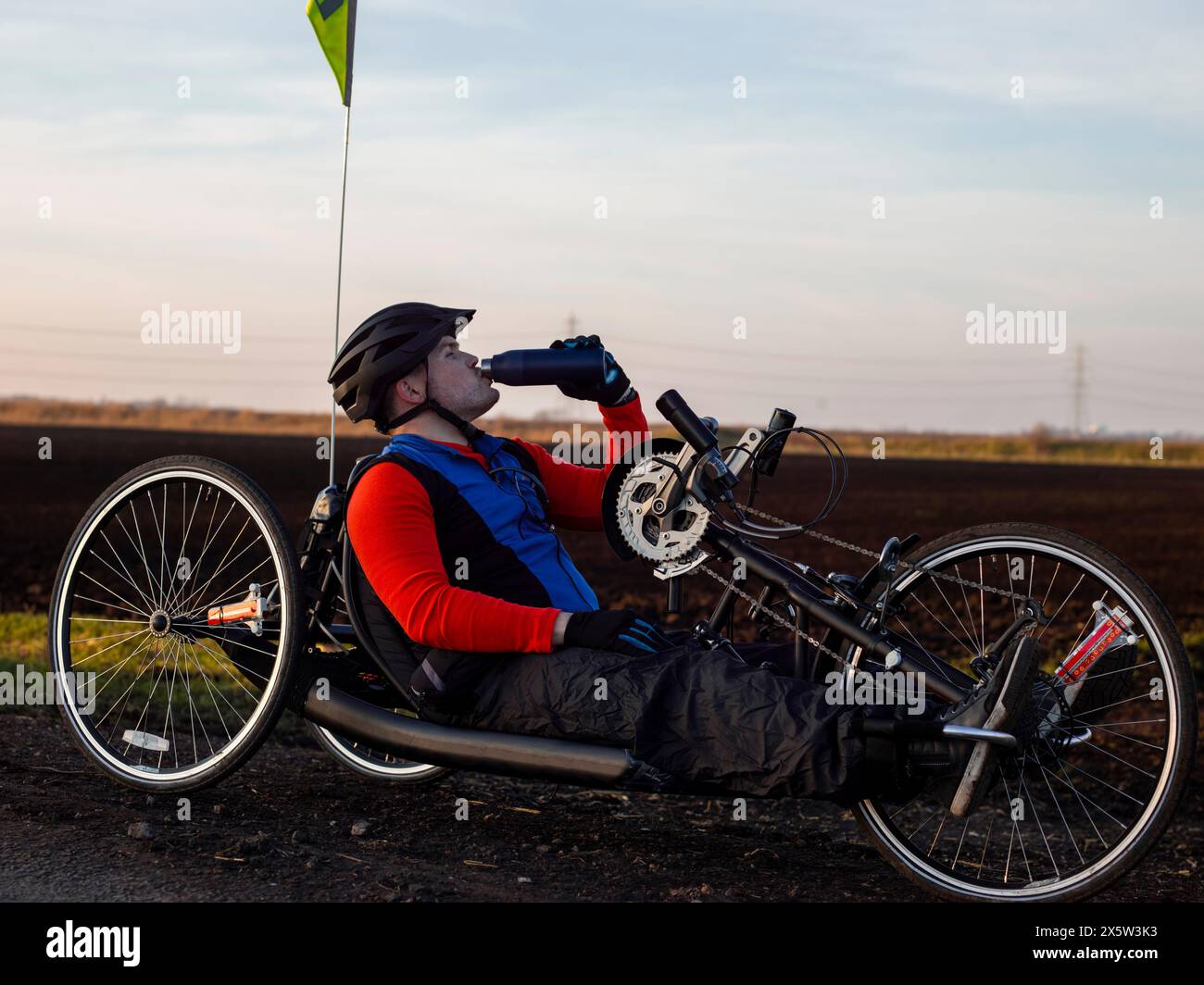 Disabled man on handcycle drinking from bottle in rural landscape Stock ...
