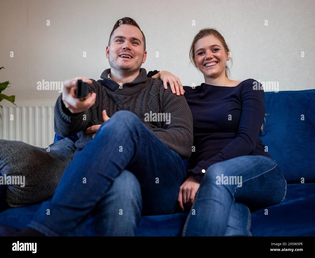 Watching television holding remote hi-res stock photography and images ...