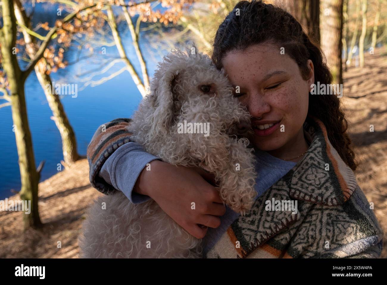 Smiling young woman hugging dog Stock Photo - Alamy