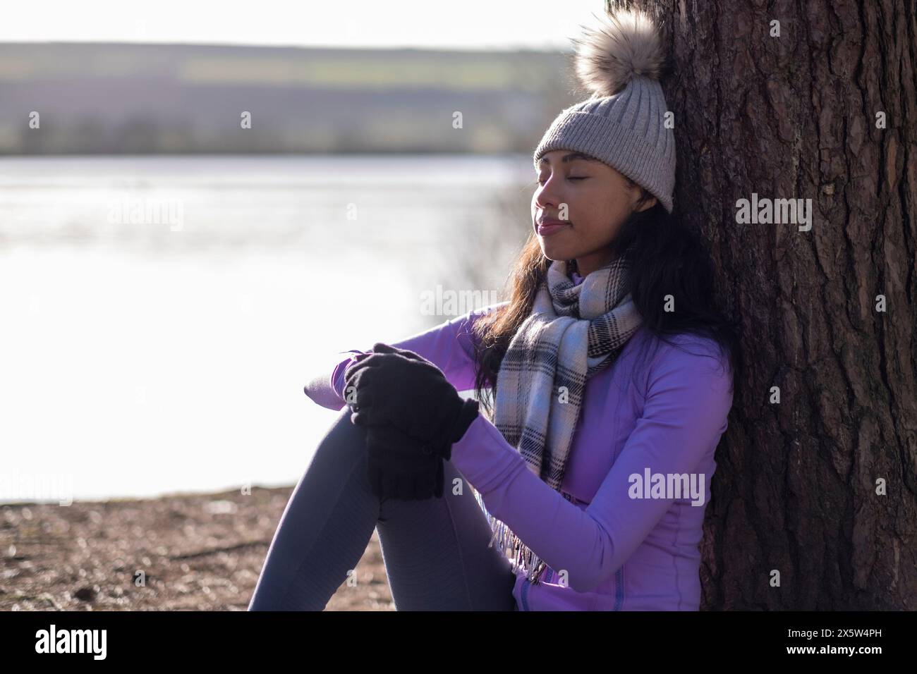 Woman sitting against tree trunk hi-res stock photography and images ...