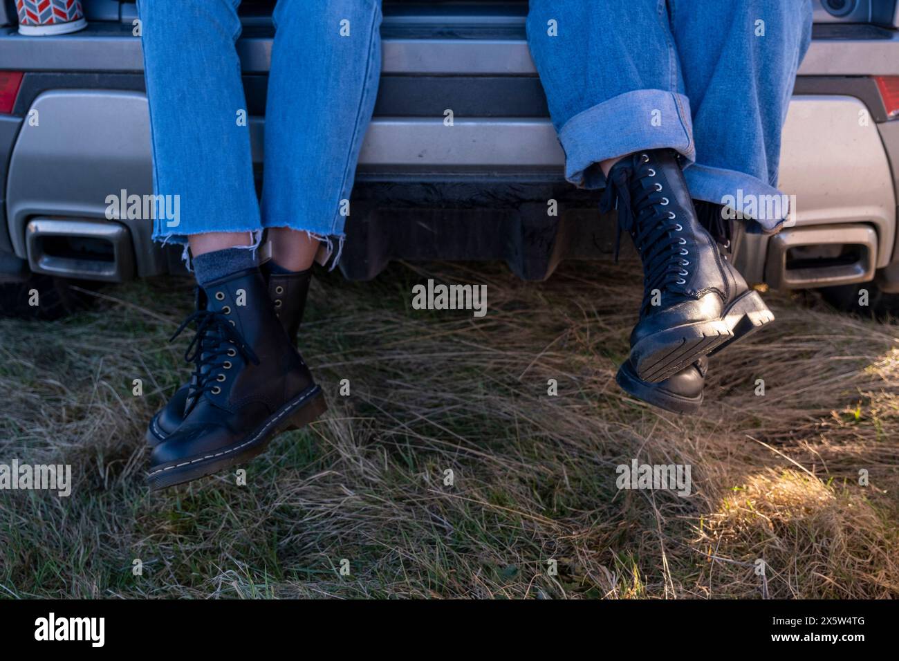 Women feet in leather boots dangling from car Stock Photo - Alamy