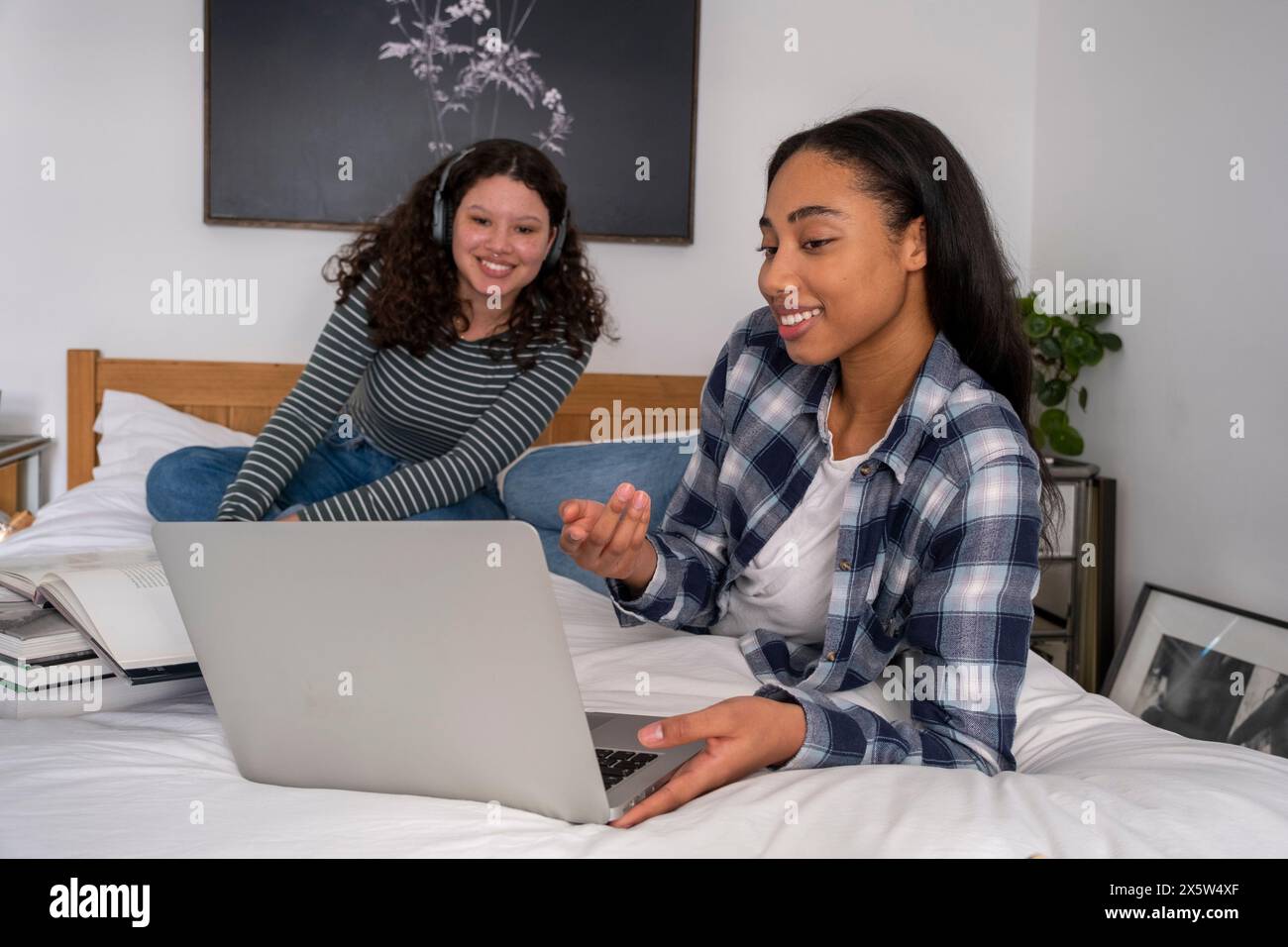 Female friends using laptop on bed Stock Photo - Alamy