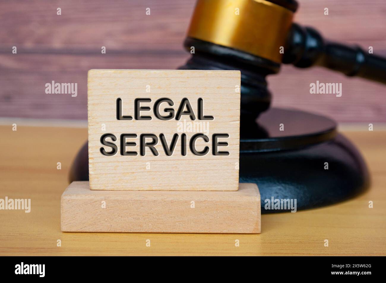 Legal service text engraved on wooden block with gavel background ...