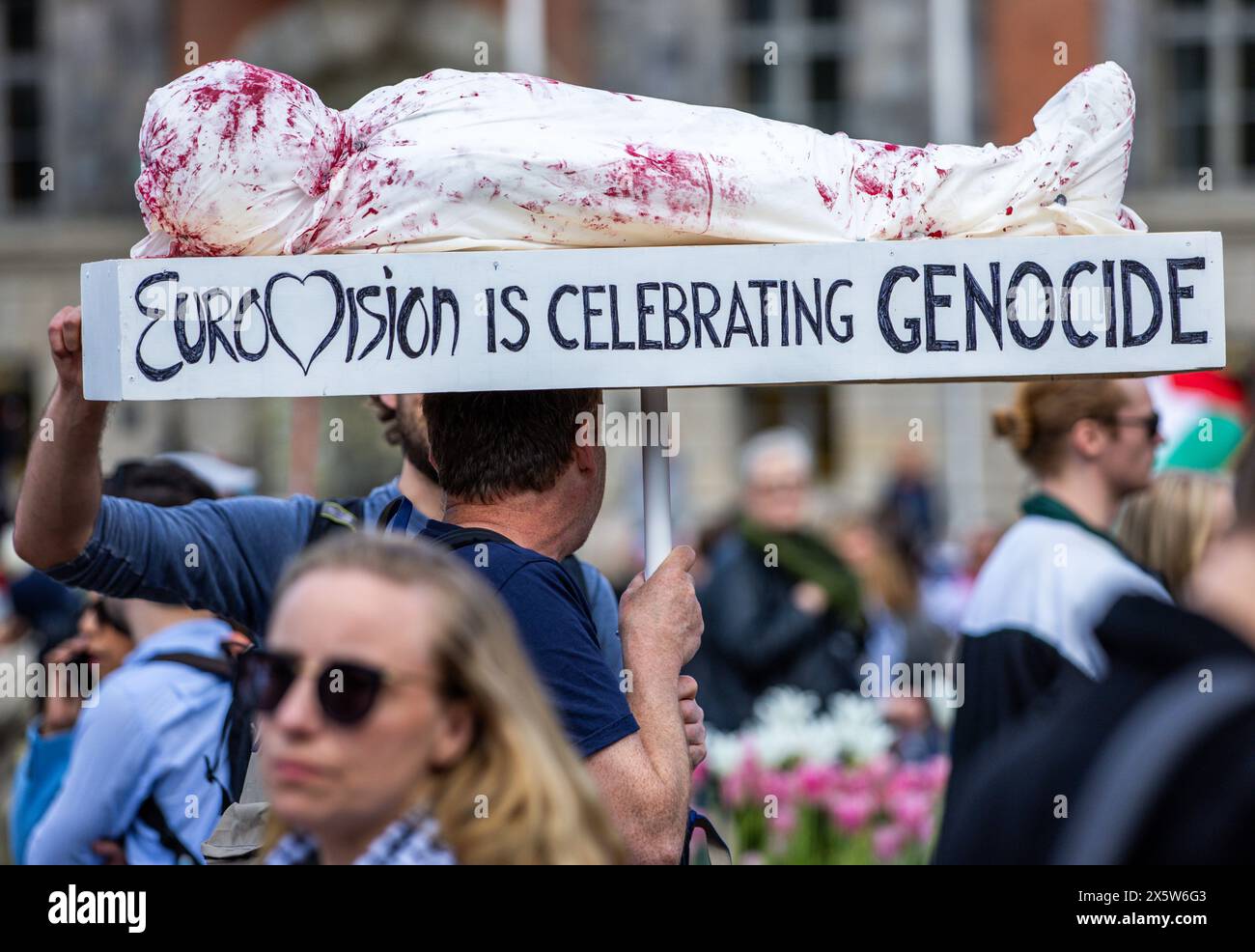 11 May 2024, Sweden, Malmö: Participants in a protest action carry a ...