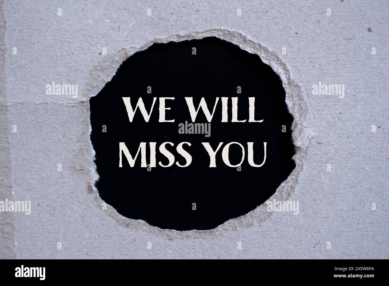 We will miss you words written on ripped paper with black background ...
