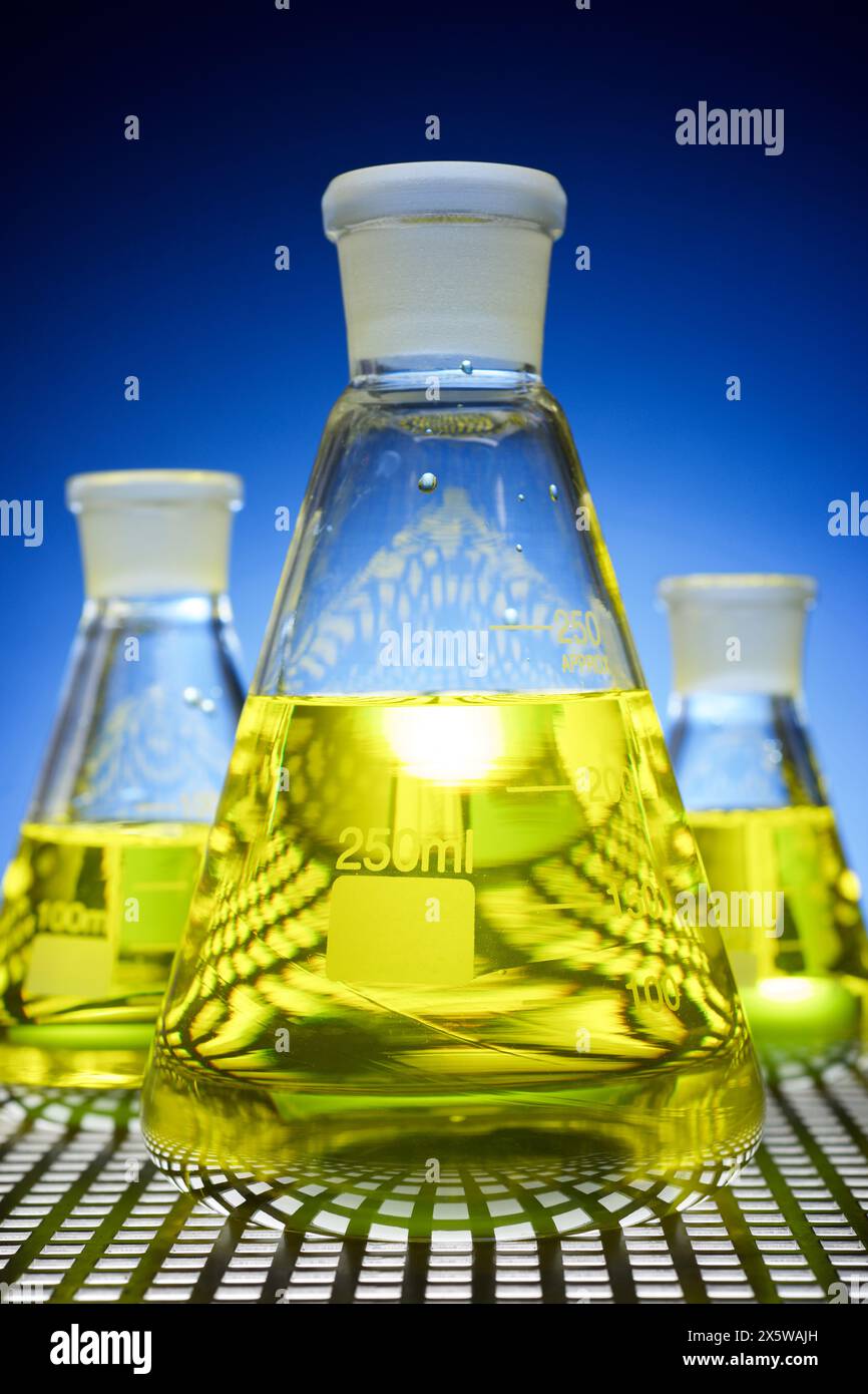 Close up of a glass beakers with yellow liquid standing in a laboratory ...