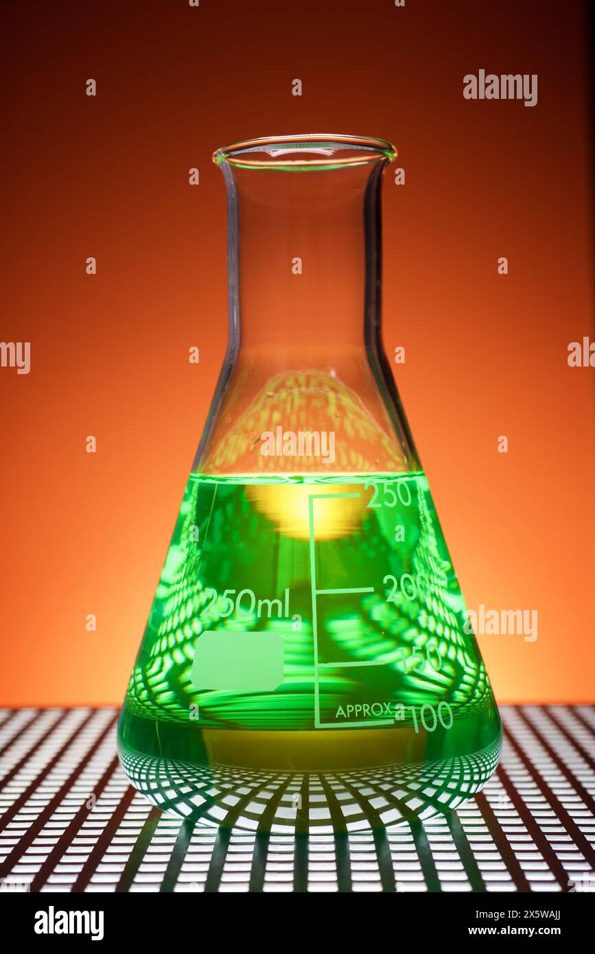 Close up of a glass beaker with green liquid standing in a laboratory ...