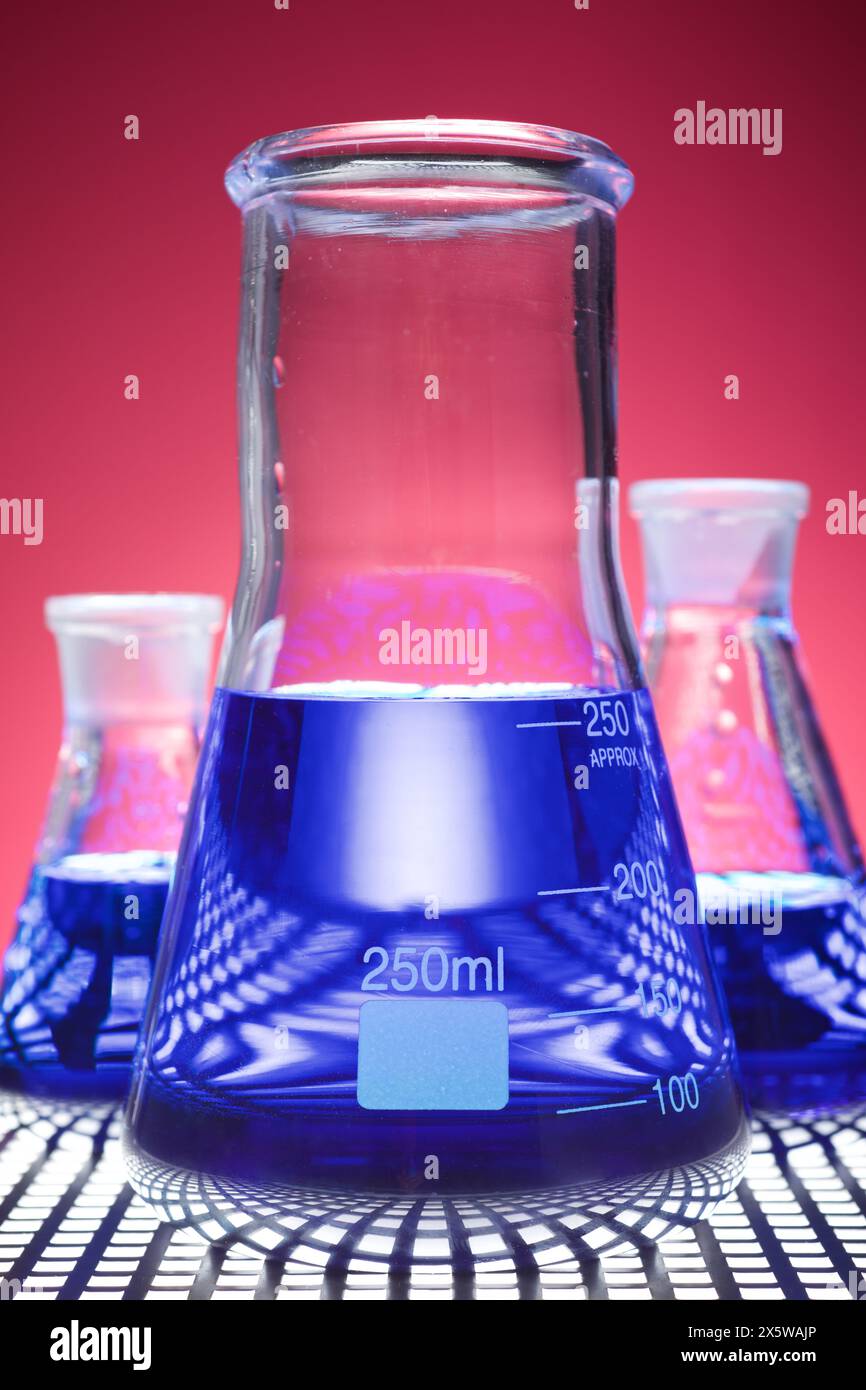 Close up of a glass beakers with blue liquid standing in a laboratory ...