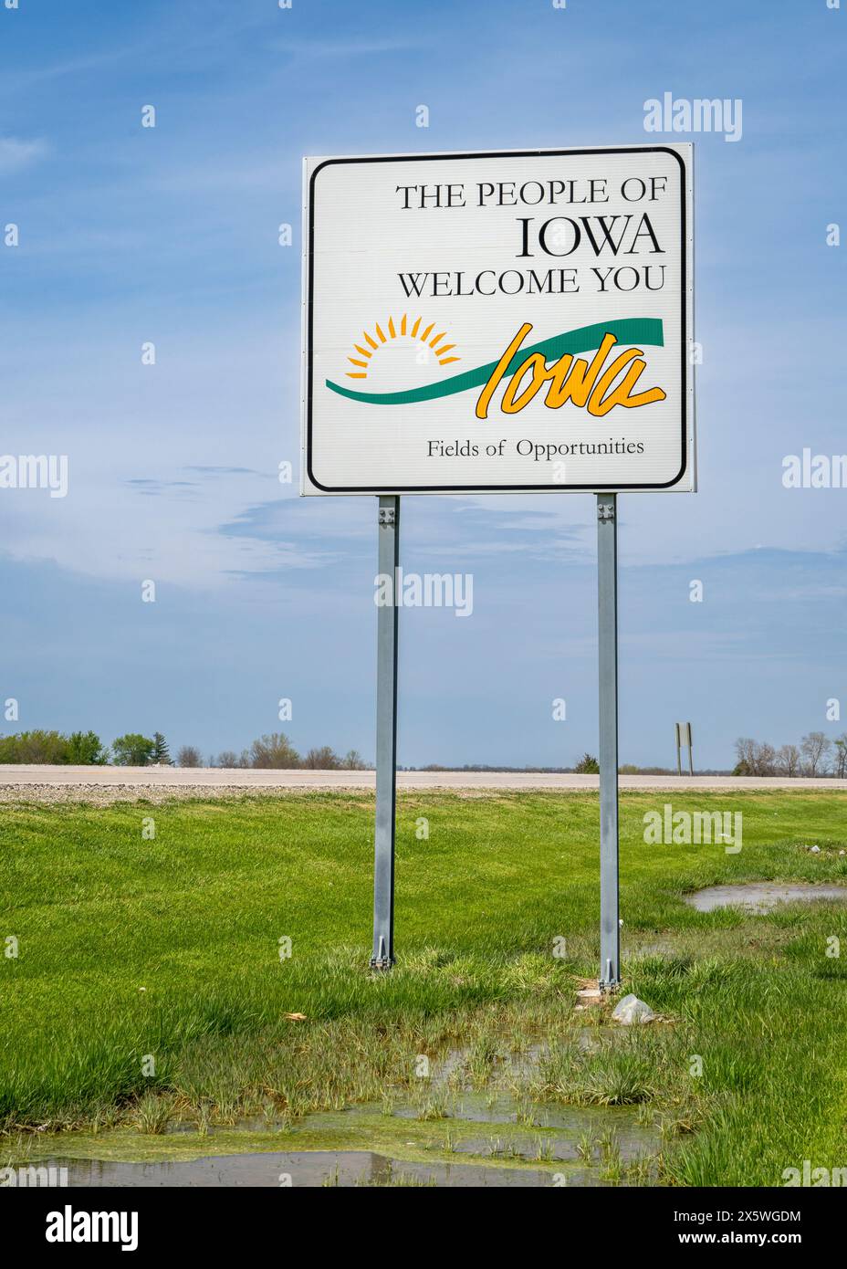 Iowa welcome roadside sign against blue sky at state border with ...