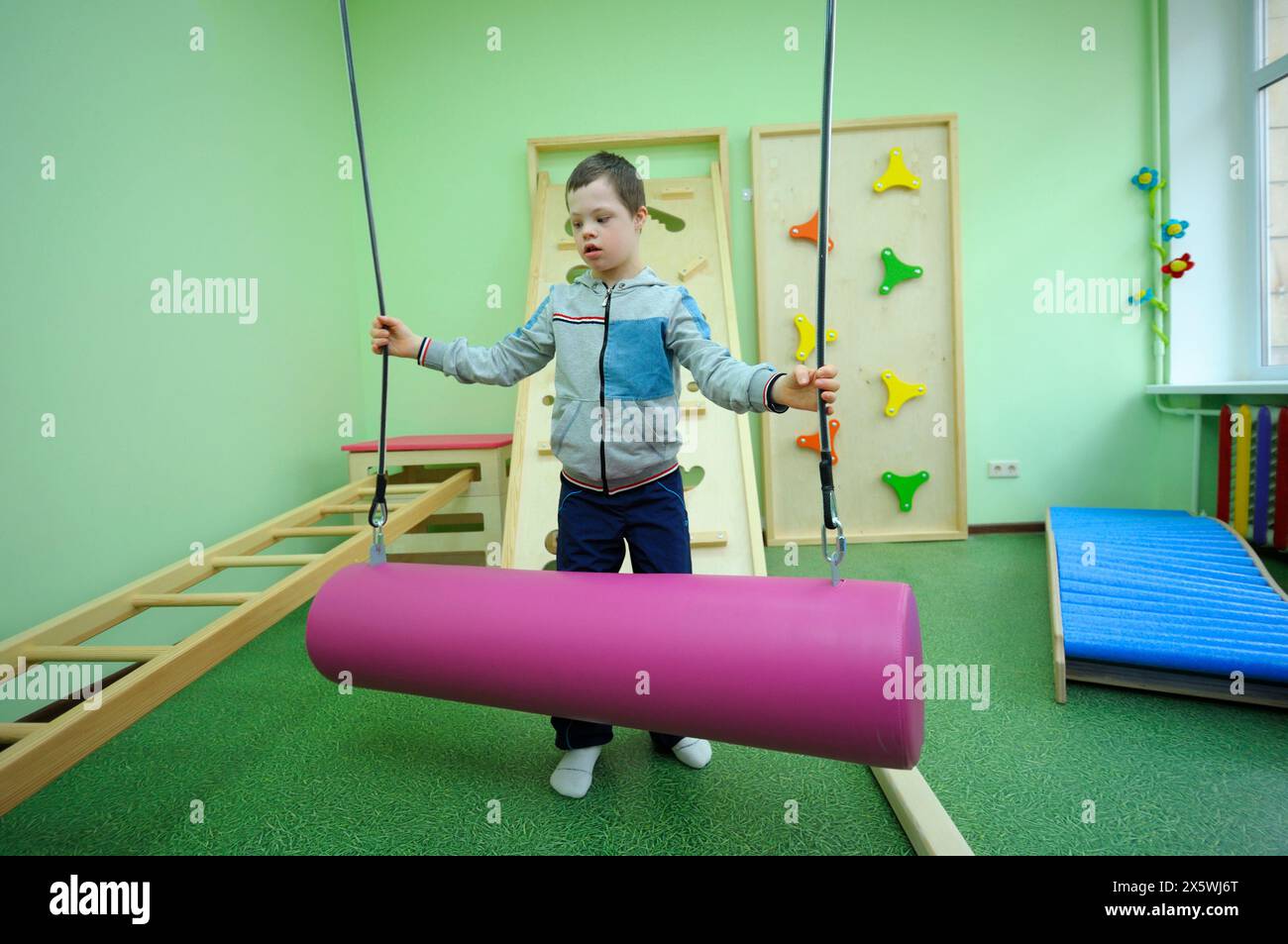 Improving motor control: Down syndrome boy doing exercises at the ...