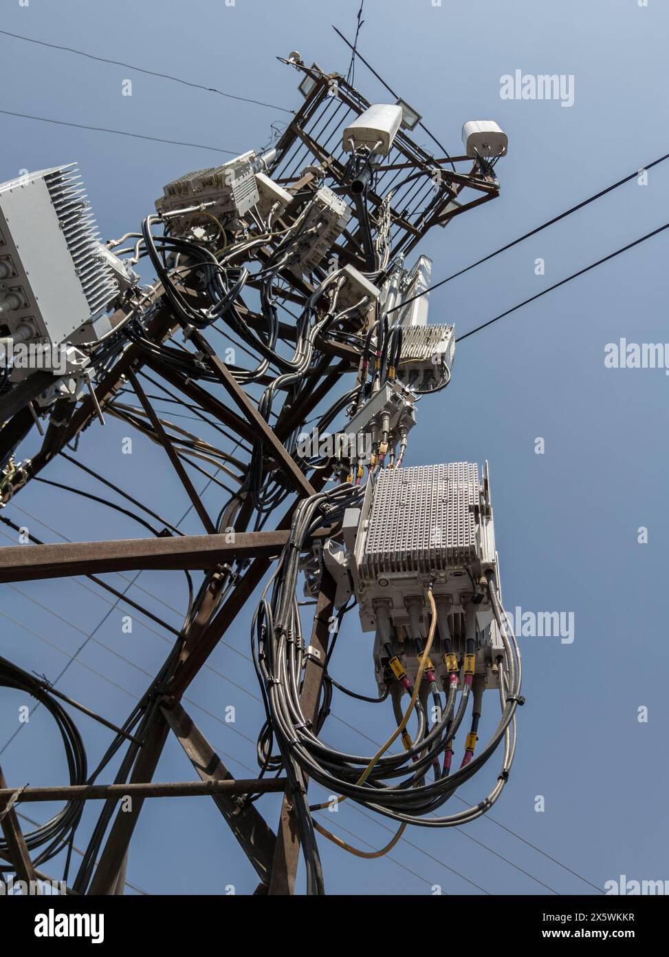 cluttered utility pole with assortment of electronic equipment ...