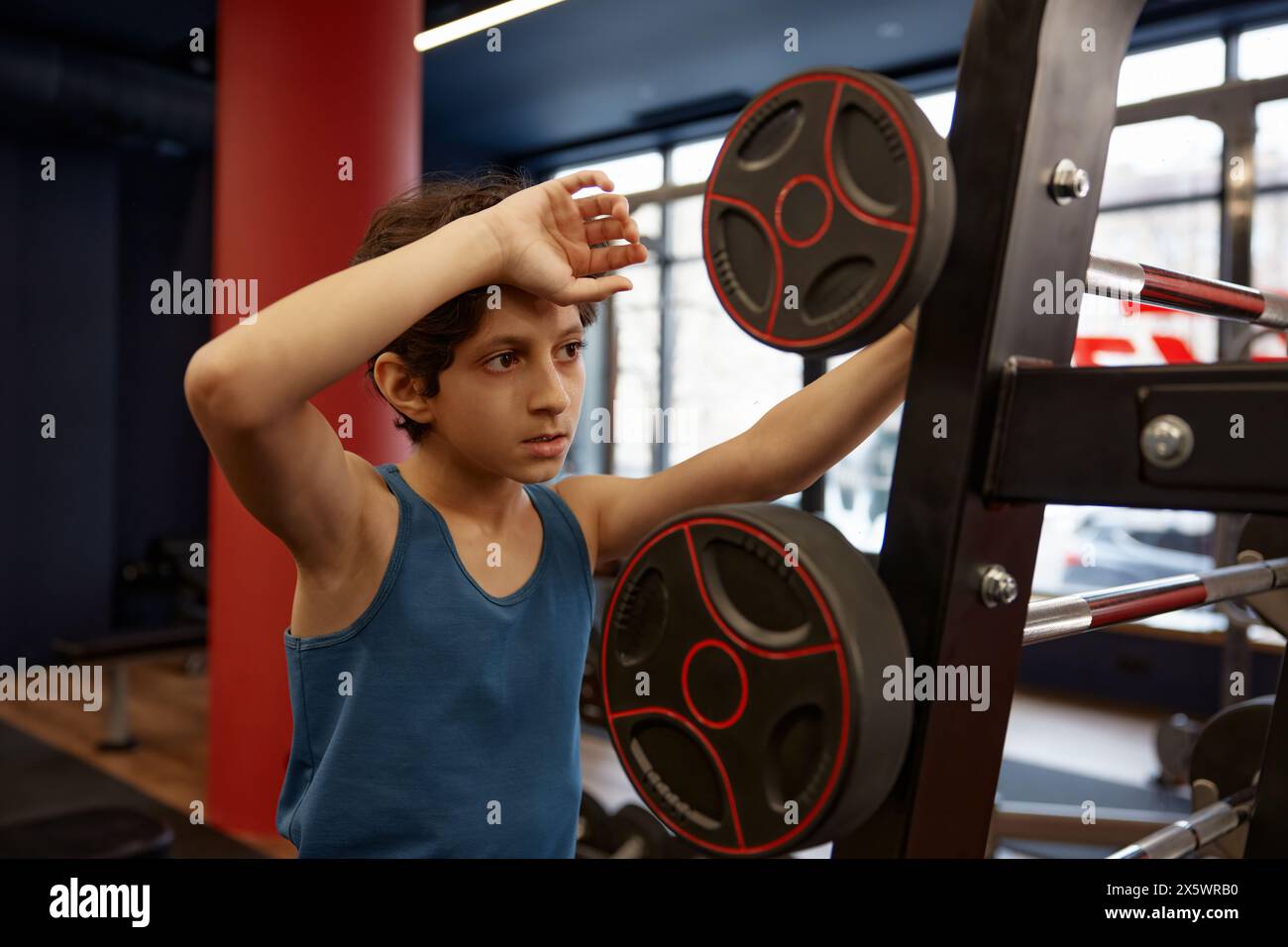 Tired preteen boy wiping sweat from his forehead with hand after ...