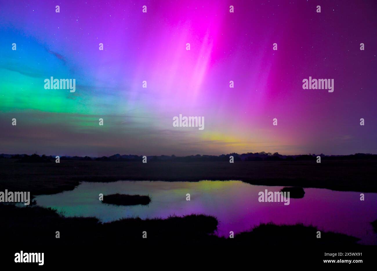 The Northern lights reflecting in a small water hole on Canada Common ...