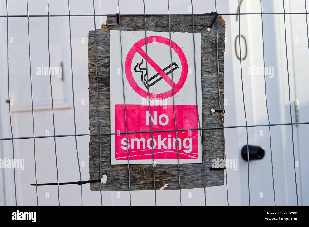 No smoking sign fixed to construction site fence Stock Photo - Alamy