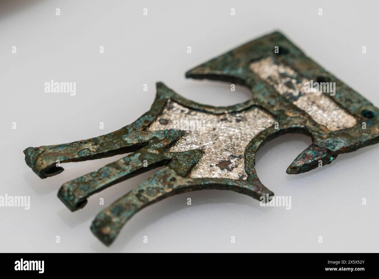 Bronze belt plate with three hooks, decorated with silver damascening ...
