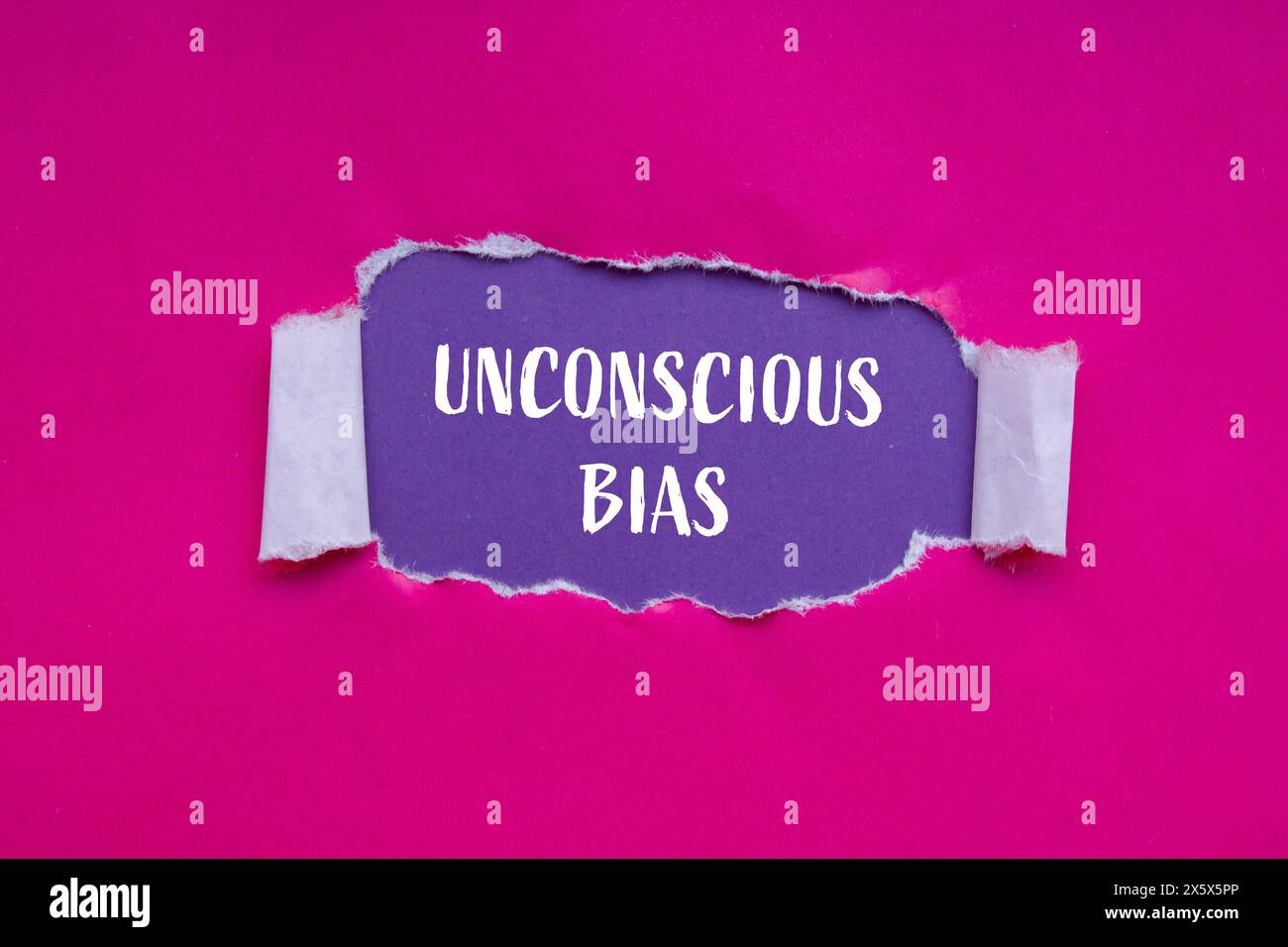 Unconscious bias words written on ripped pink paper with purple background. Conceptual ...