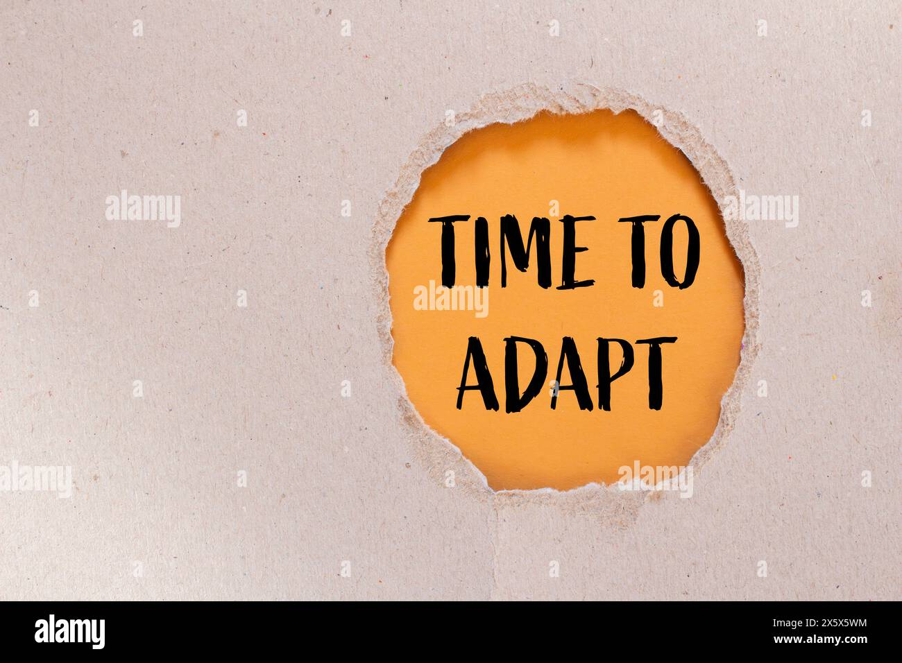 Time to adapt written on ripped paper with orange background ...