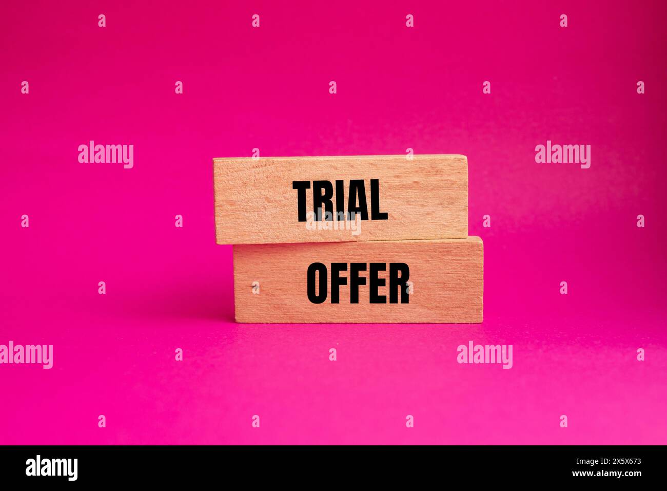 Trial offer words written on wooden blocks with pink background ...