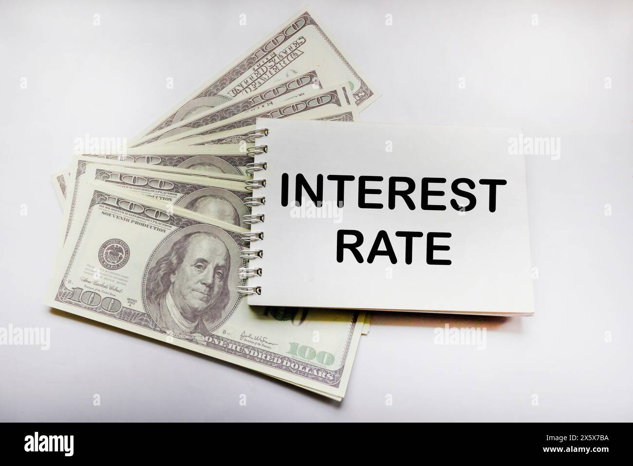 US dollars on white background with text on notepad SHOWING INCREASING ...