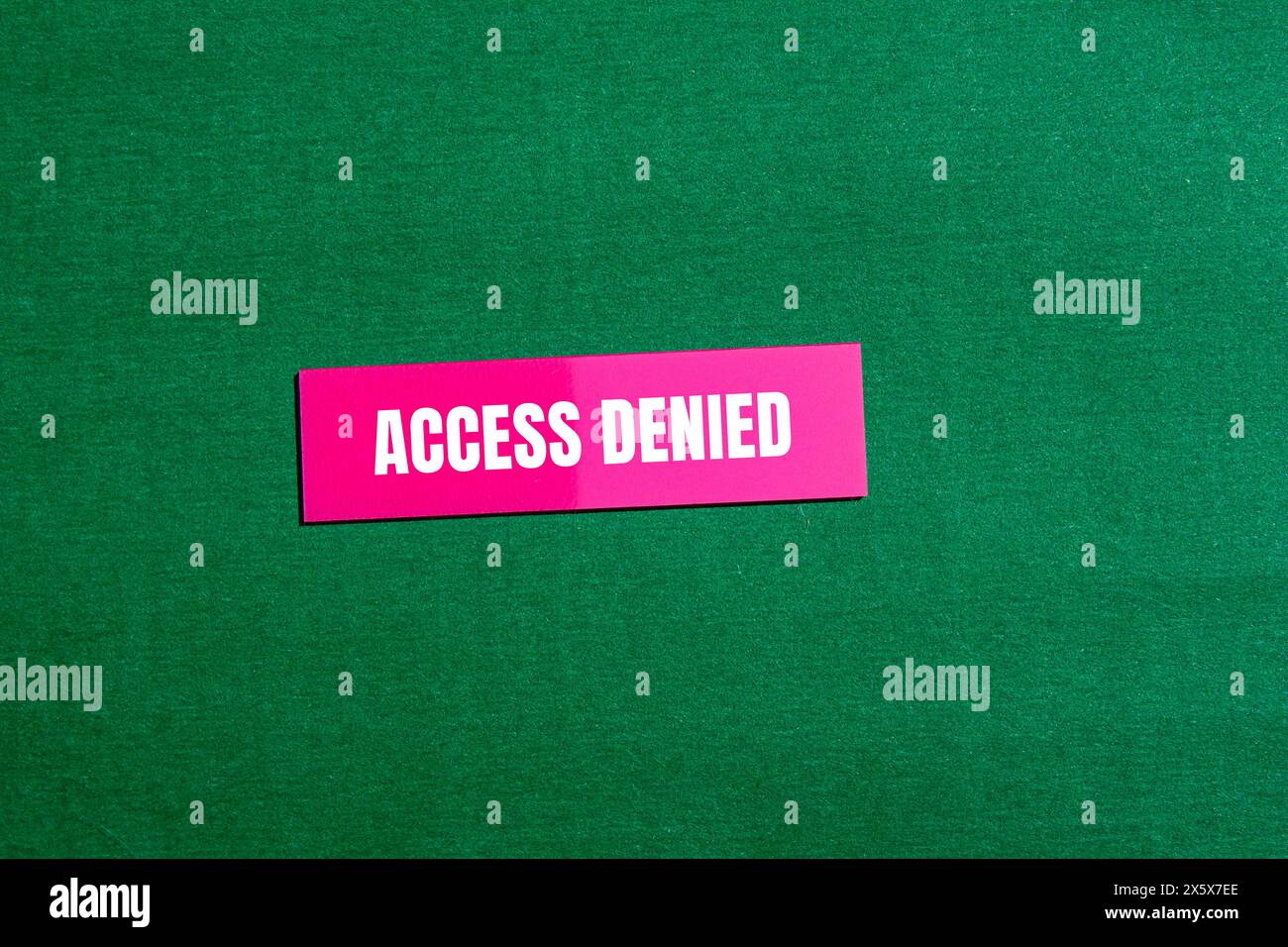 Access denied words written on pink paper sticker with green background ...