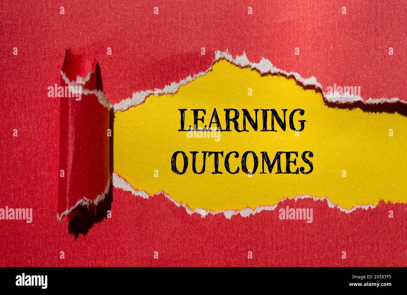 Learning outcomes words written on ripped red paper with yellow ...