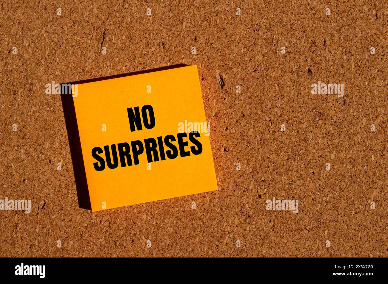 No surprises words written on orange paper sticker with brown ...