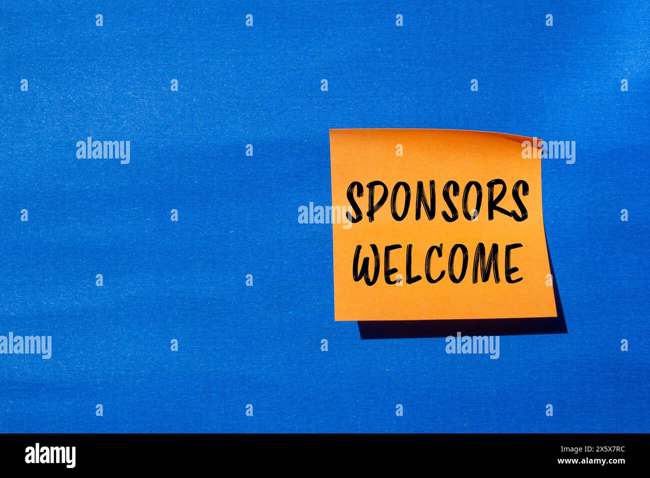 Sponsors welcome words written on orange paper sticker with blue ...