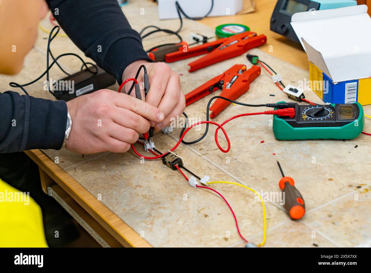 A man doing electronic assembly with a voltage meter Stock Photo - Alamy
