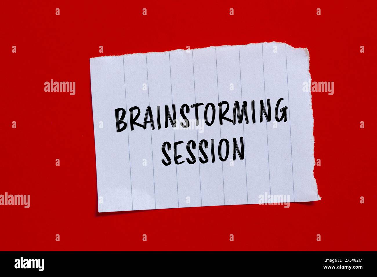 Brainstorming session words written on ripped paper with red background ...