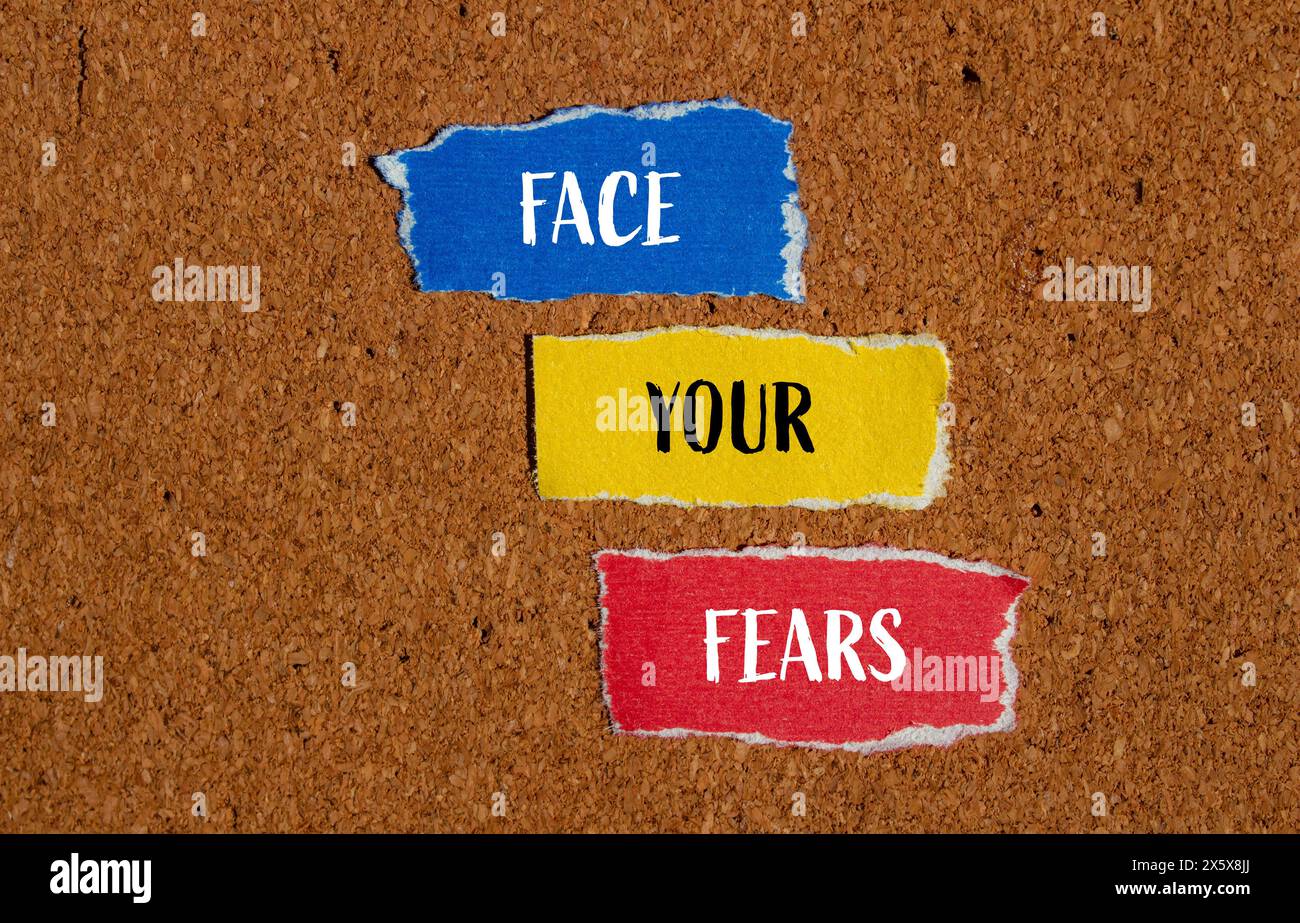 Face your fears words written on ripped paper pieces with brown ...