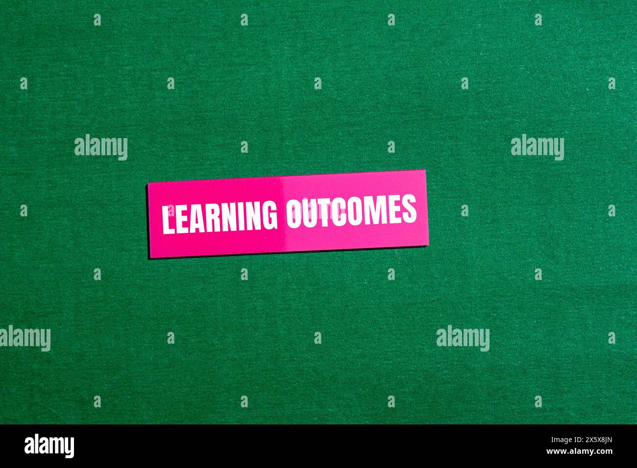 Learning outcomes words written on pink paper sticker with green ...