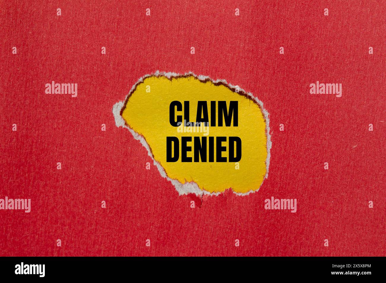 Claim denied words written on ripped red paper with yellow background ...