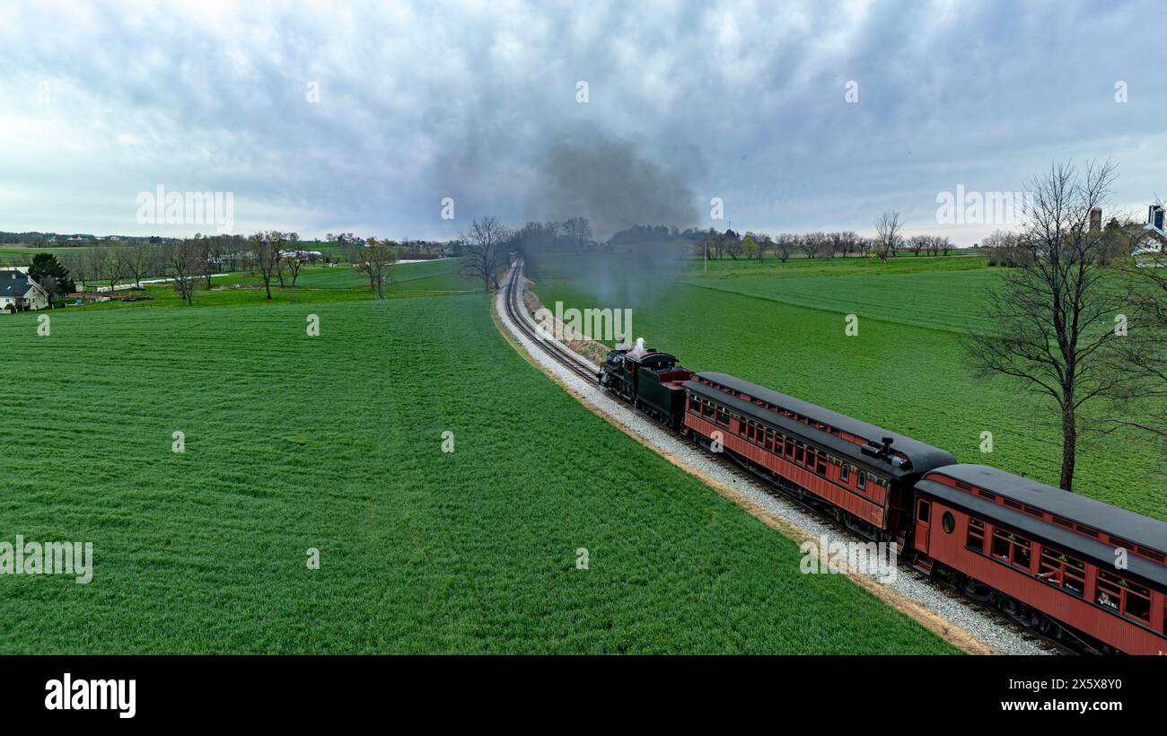 Captivating aerial photo of a historic steam train emitting a dense ...