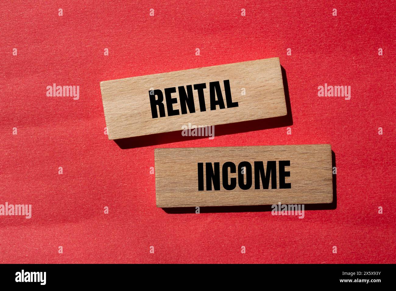 Rental income words written on wooden blocks with red background ...