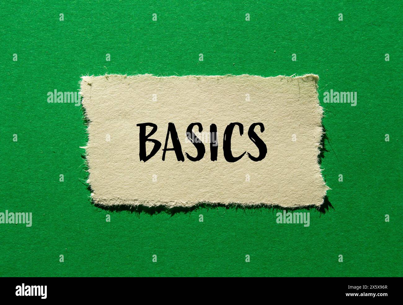 Basics word written on ripped paper with green background. Conceptual ...
