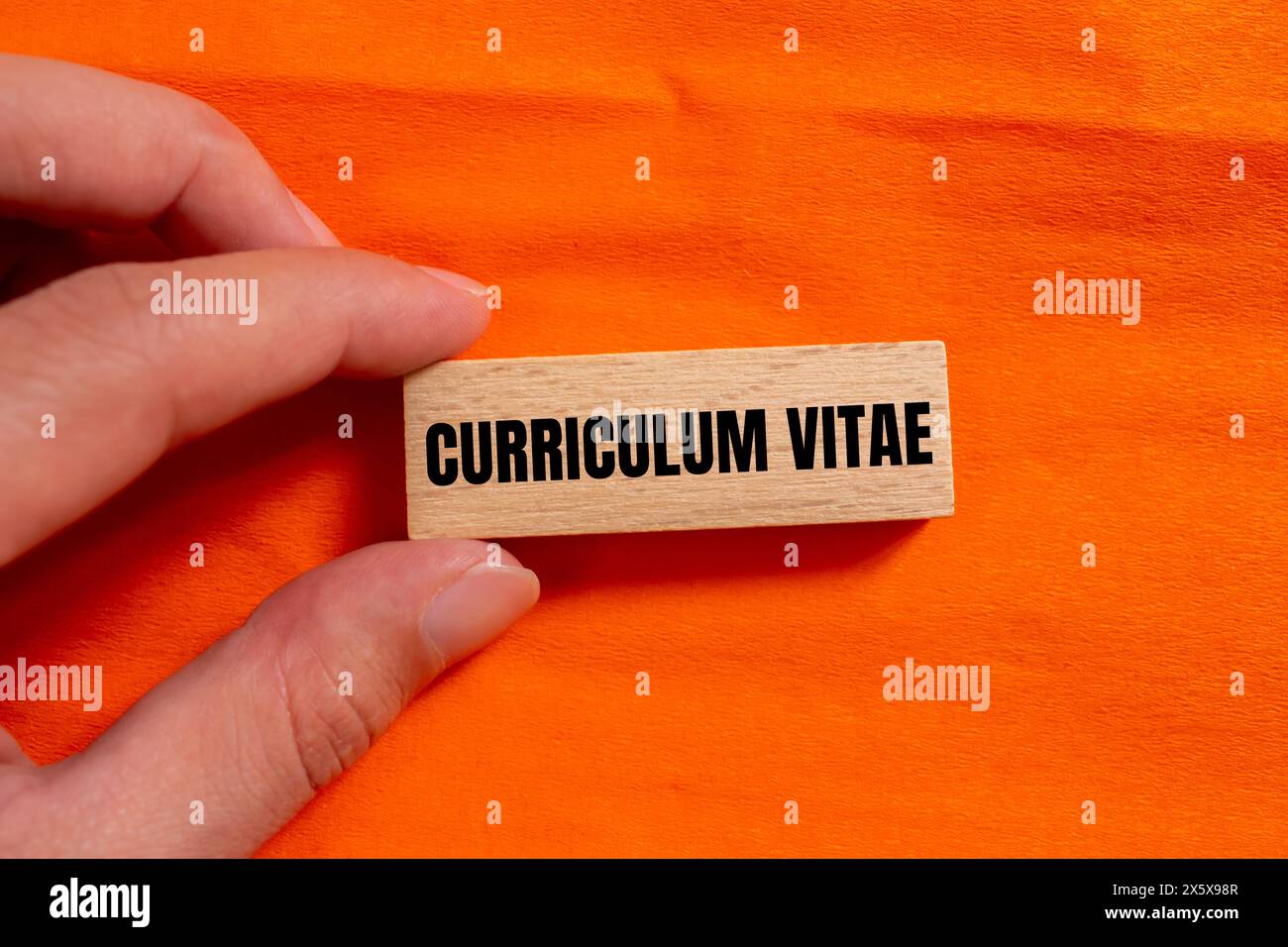 Curriculum vitae words written on wooden block with orange background ...