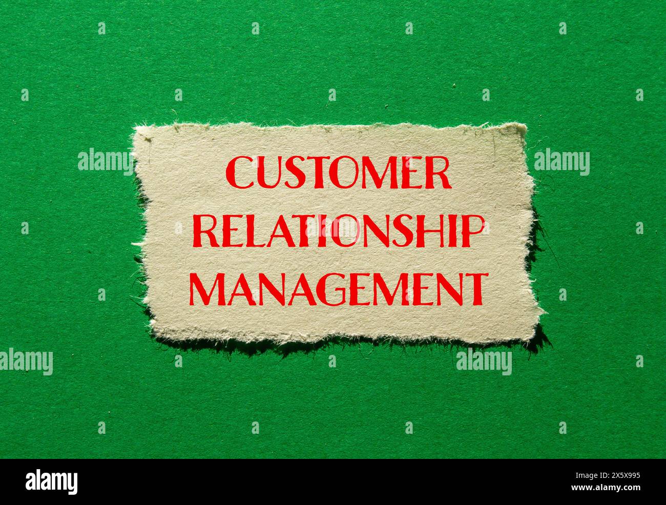 Customer relationship management words written on ripped paper with ...
