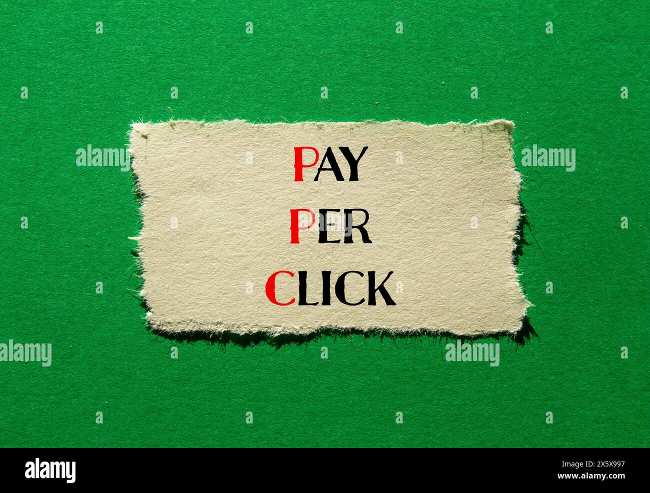 Pay per click words written on ripped paper with green background ...