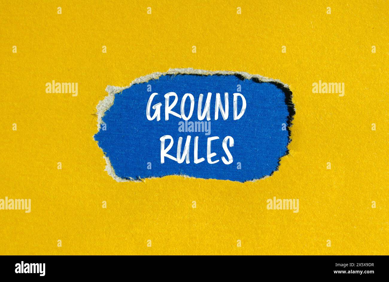 Ground rules words written on ripped yellow paper with blue background ...