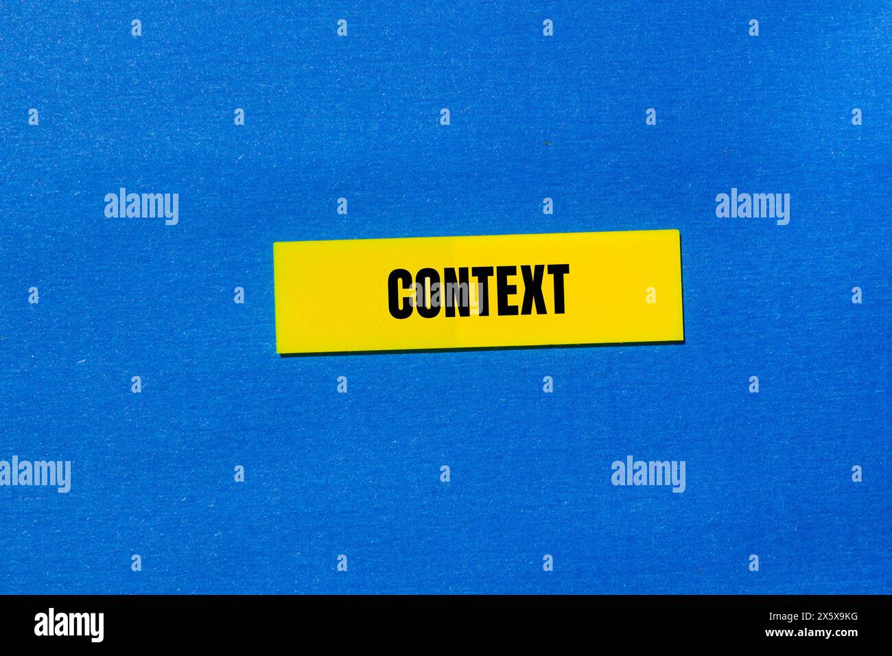 Context word written on yellow paper sticker with blue background ...