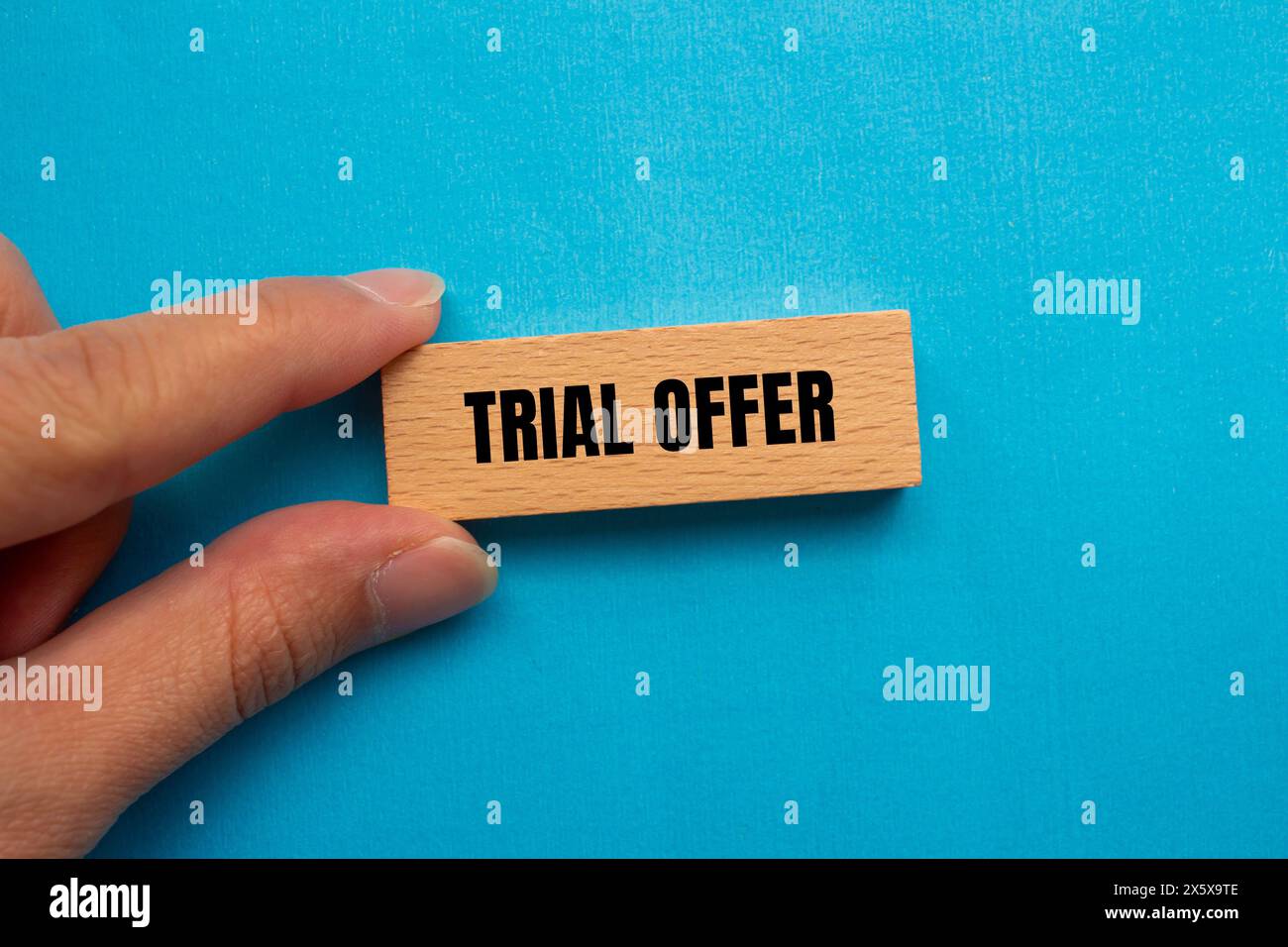 Trial offer words written on wooden block with blue background ...