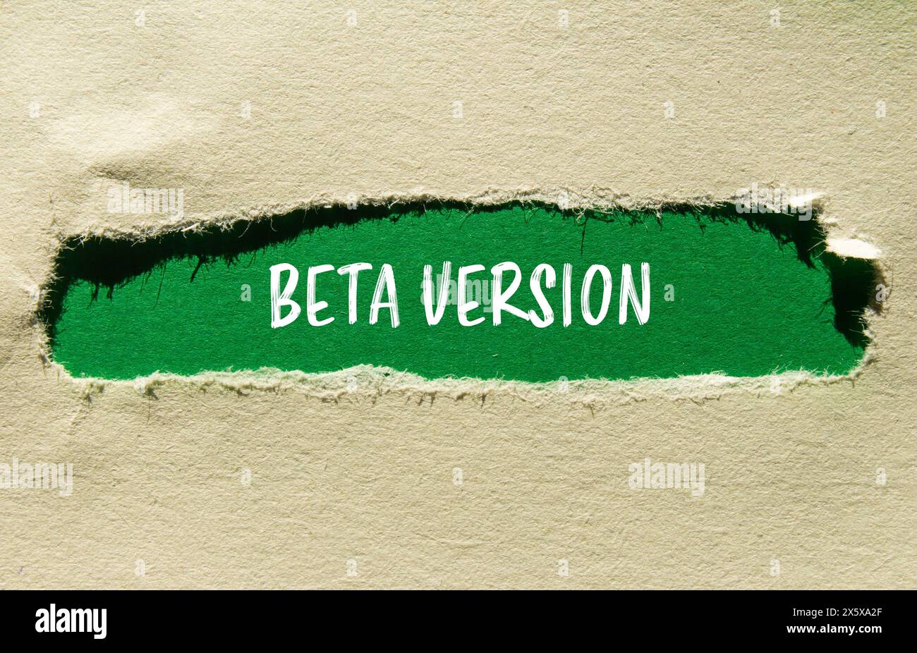 Beta version words written on ripped paper with green background ...