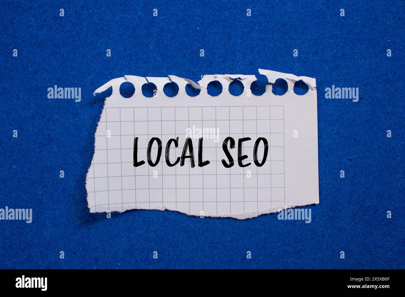 Local seo words written on ripped white paper with blue background ...