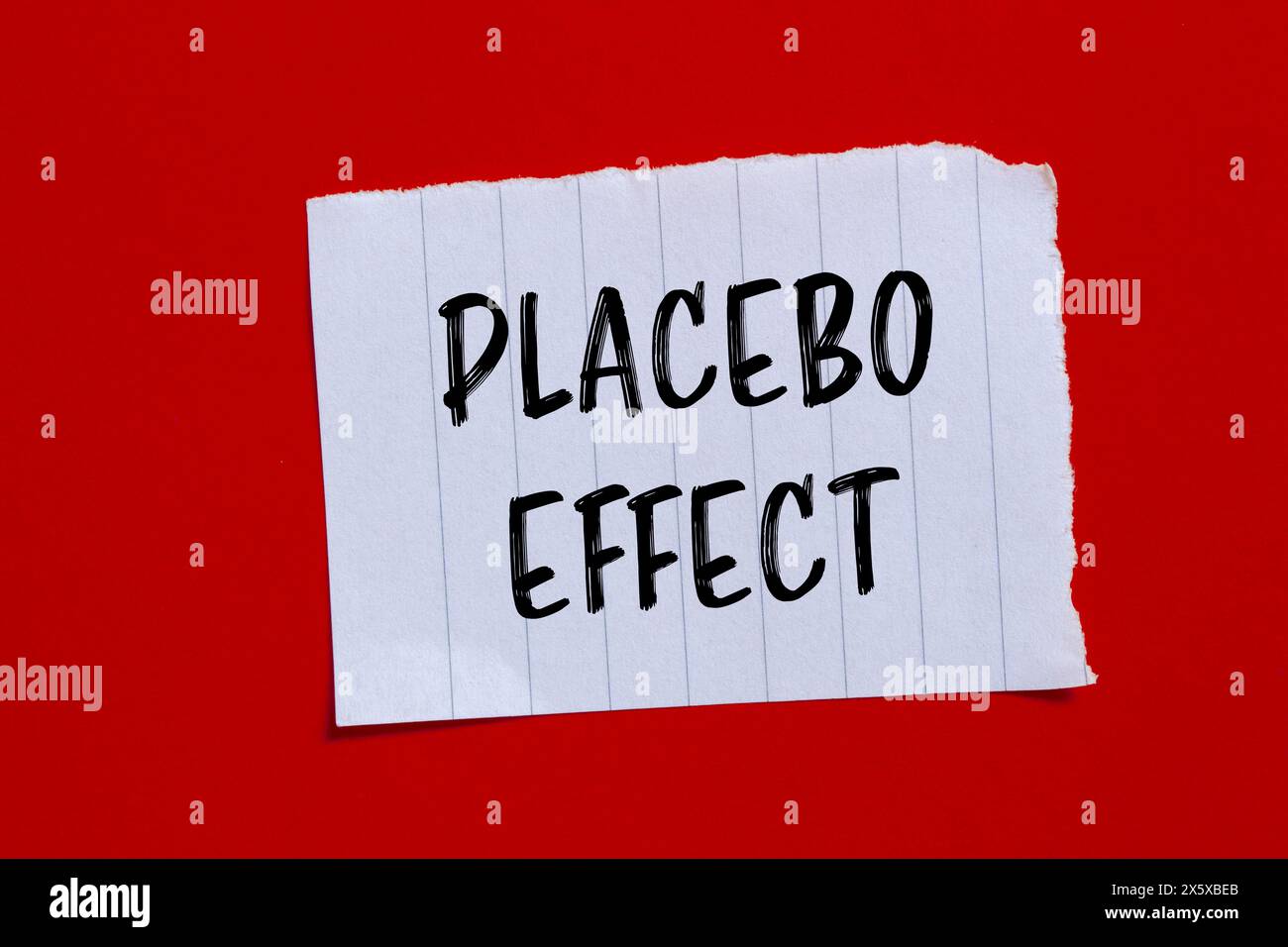 Placebo effect words written on ripped paper with red background ...