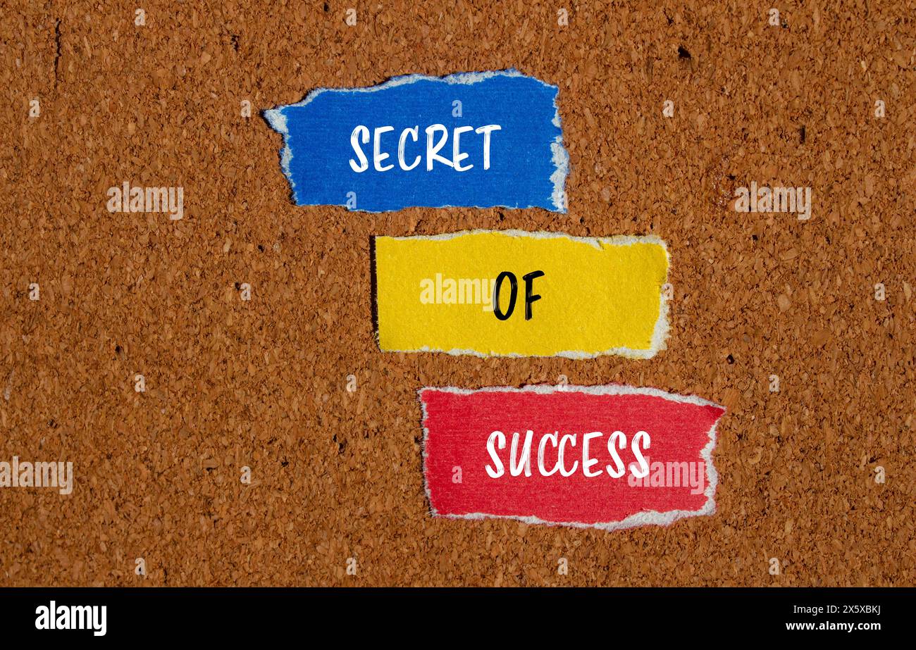 Secret of success words written on ripped paper pieces with brown ...