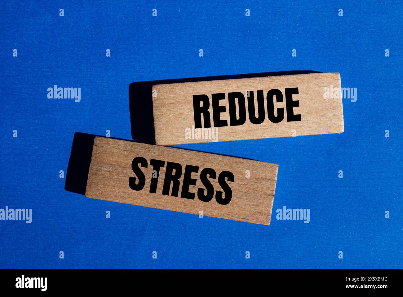 Reduce stress words written on wooden blocks with blue background ...