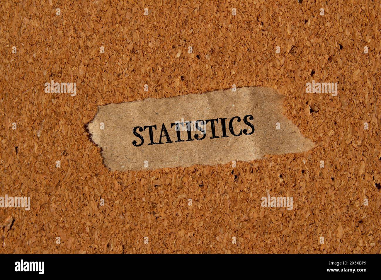 Statistics word written on ripped paper piece with brown background ...