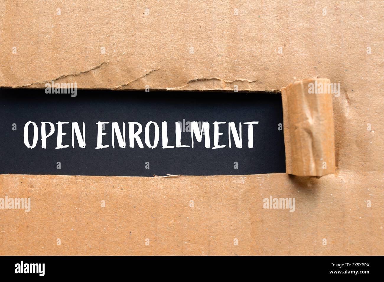 Open enrollment words written on ripped cardboard paper with black ...