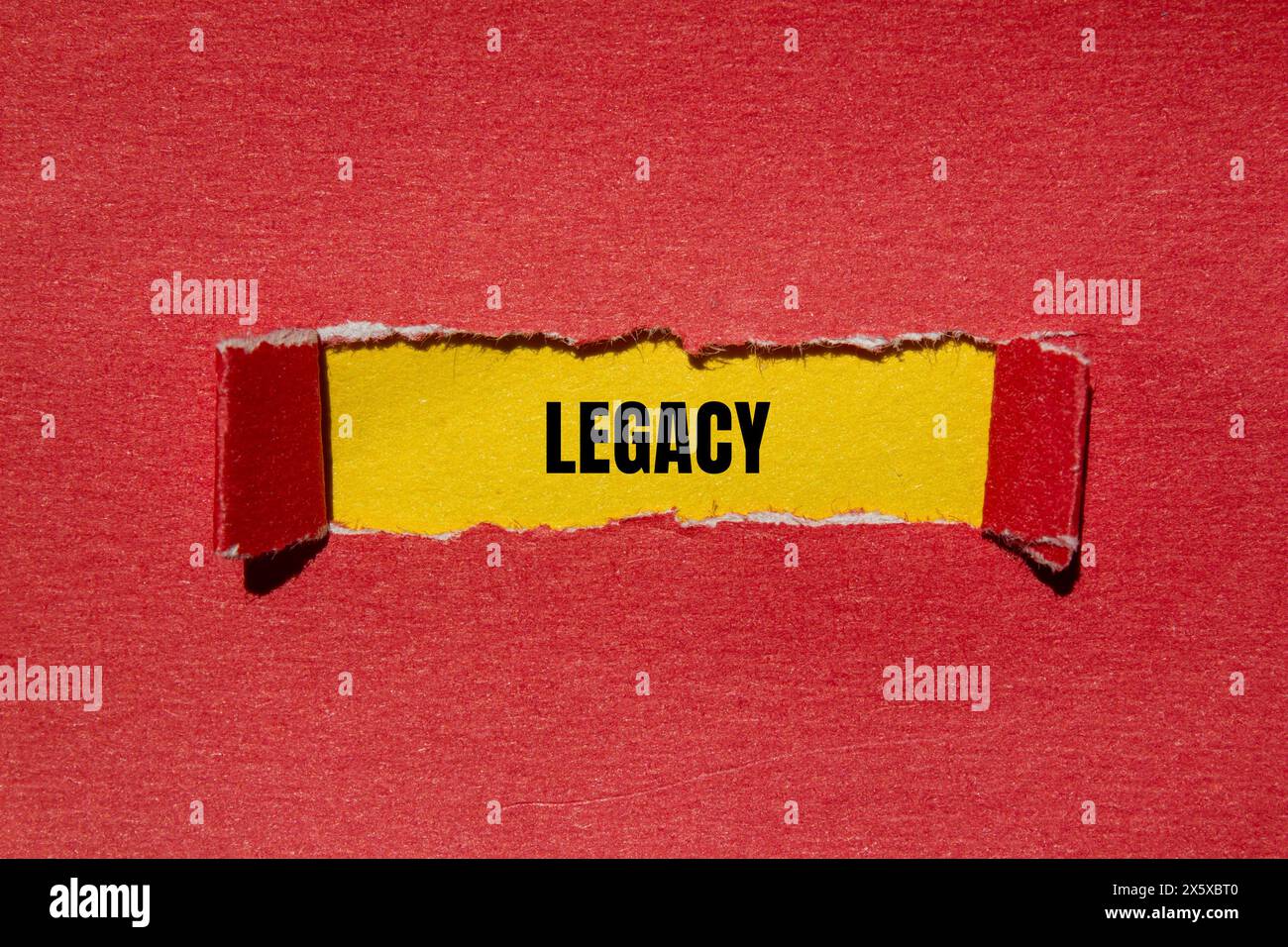 Legacy word written on ripped red paper with yellow background ...