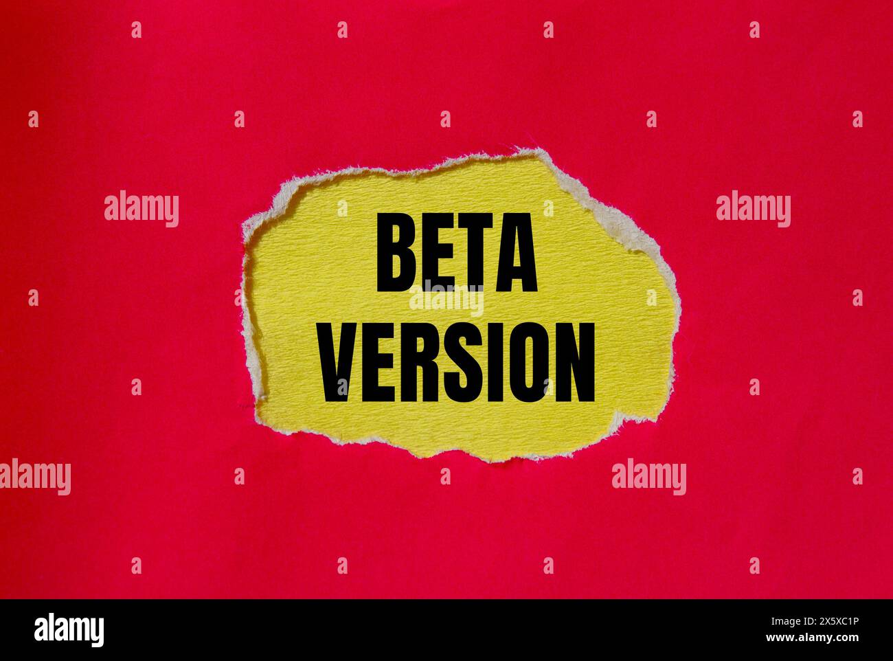 Beta version words written on ripped red paper with yellow background ...